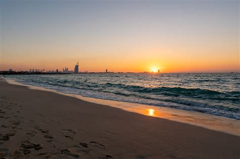 두바이 의 해변에서 놀라운 오렌지 일몰 태양에서 오는 아름다운 오렌지 색상과 아랍 에미리트 연방의 걸프 바다 파도와 해안에 반영