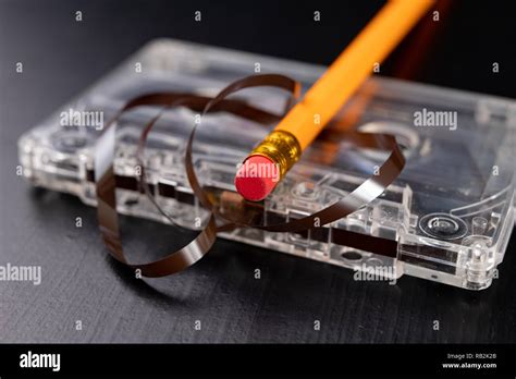 Audio Cassette And Pencil On A Black Table Old Magnetic Data Carrier