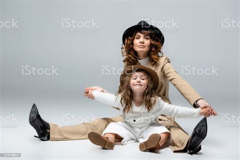 우아한 어머니와 딸 에 흰색 과 베이지 색 의상과 모자 회색 배경에 바닥에 포즈 딸에 대한 스톡 사진 및 기타 이미지 딸