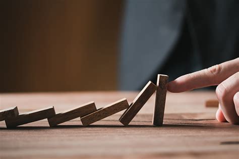 나무 게임 전략 사업가 손 지속적인 토플 또는 위험 전략과 비즈니스에 대한 성공적인 개입 개념에서 떨어지는 나무 도미노 효과를 중지 이미지 개념에 대한 스톡 사진 및 기타