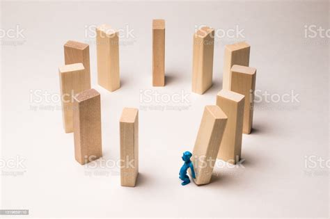 장난감 남자가 나무 블록을 밀어 넣습니다 치명적인 일련의 사건의 시작 미래의 어떤 시점에서 모두가 여전히 자신의 실수에 대한 비용을 지불해야합니다 카르마 개념 떨어짐에 대한