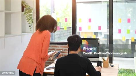 현대식 사무실에서 컴퓨터 모니터에 표시된 디자인 프로젝트에 대해 논의하는 두 명의 동료 20 24세에 대한 스톡 사진 및 기타 이미지 20 24세 2명 30 34세