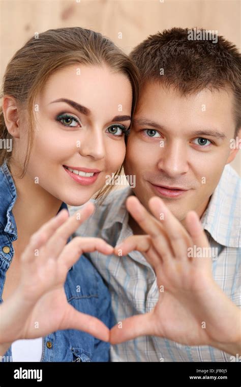 Portrait Of Smiling Beautiful Girl And Her Boyfriend Making Shape Of