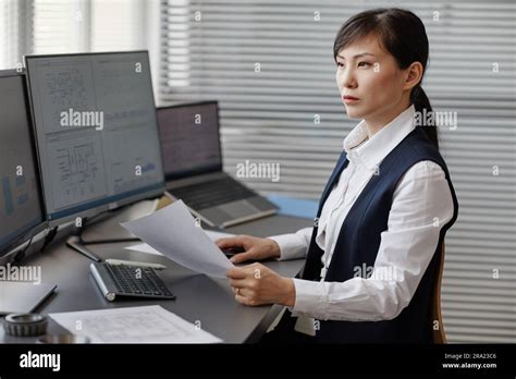 side view portrait of asian woman as female engineer using computer