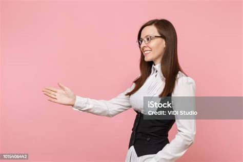 파스텔 핑크 바탕에 격리 하는 악수에 대 한 손 주는 안경에 사이드 보기 젊은 즐거운 성공적인 비즈니스 여자 여자 보스입니다