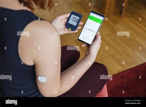 Woman Comparing Result Of Glucose Level Check On The Traditional Glucometer And On The Mobile