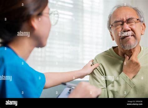 Doctor Woman Examines Lymph Nodes On Elderly Neck To Determine If