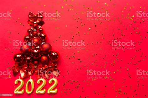 유리 공으로 만든 크리스마스 트리와 숫자 2022 금별과 빨간색 배경에 촛불에서 크리스마스 배경 새해 평탄 공간을 복사합니다 인사말 카드 축제 분위기 2022년에 대한 스톡