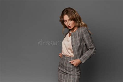 Sensual Businesswoman Holding Lipstick And Kneeling On Chair Stock