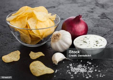검은 돌 테이블 배경에 마늘 붉은 양파와 소금 양파 풍미와 감자 감자칩 칩 유리 그릇 접시 0명에 대한 스톡 사진 및 기타