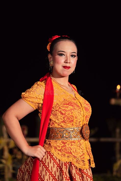 Balinese Woman With Makeup While Wearing An Orange Dress Called Kebaya