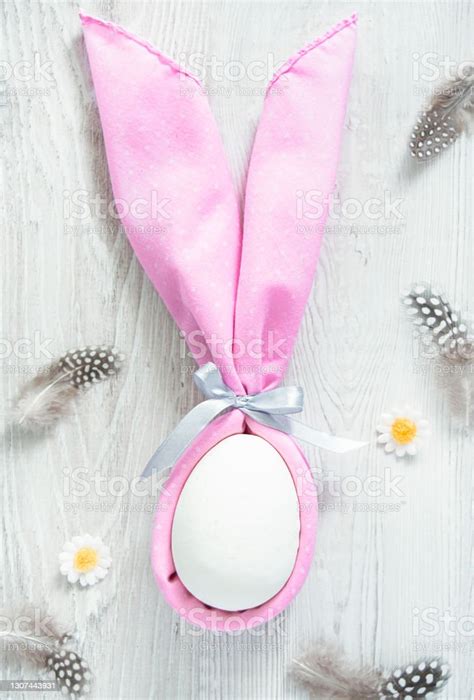 메추라기 깃털이 밀착된 테이블에 부활절 토끼의 형태로 냅킨 라이트 백 귀 부분에 대한 스톡 사진 및 기타 이미지 귀 부분
