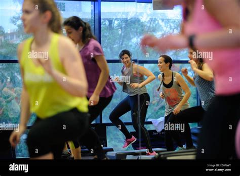 Young Woman Having Fun During A Step Aerobics Fitness Class At The Gym