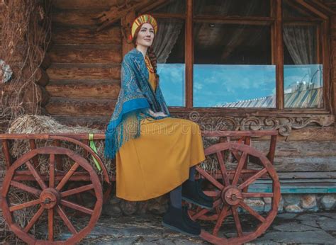 Russian Beauty In Traditional Dress Sits On A Cart With Hay Stock Image