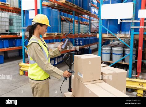 Female Worker Scanning Package With Barcode Scanner While Using Digital