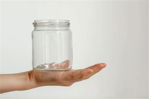 Premium Photo Hand Holding Empty Glass Jar Isolated On White Background