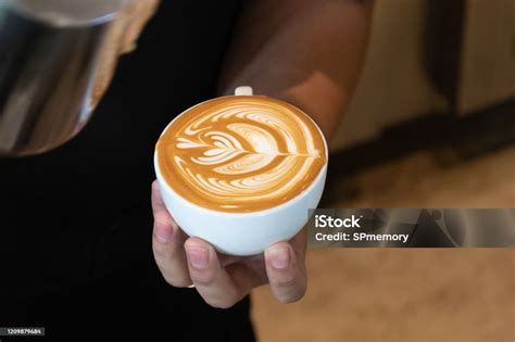 바리스타에 의한 라떼 아트는 우유와 커피에 초점을 맞춥니다 전문 바리스타가 커피 컵에 찐 우유를 부어 아름다운 라떼 아트를 만듭니다 가정 생활에 대한 스톡 사진 및 기타