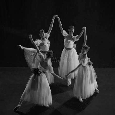 Four Ballerinas Hold Hands As They Perform Delicate Ballet Pose Race