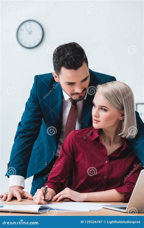 Attractive Young Businessman And Businesswoman Flirting Stock Image