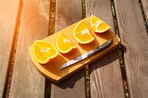 칼을 들고 선광에 나무 갈색 테이블에 도마에 오렌지 과일의 잘라 낸 조각을 식욕을 돋우는 건강한 식습관 과일 여름 화창한 0명에 대한 스톡 사진 및 기타 이미지 Istock