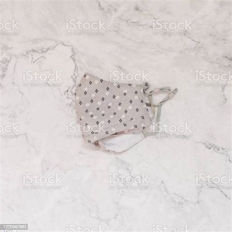 아름 다운 직물 얼굴 마스크입니다 베이 지 내츄럴 한 색상 대리석 배경에 호흡 붕대 얼굴 바이러스 및 전염병