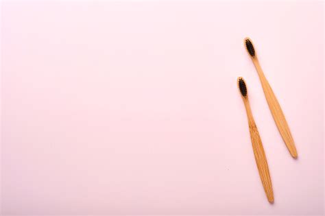 복사 공간이있는 분홍색 색상 배경에 치아 위생 및 구강 치과 치료 제품 친환경 대나무 칫솔과 면꽃 플랫 레이 상단 뷰 컴포지션
