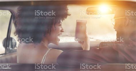 전화로 Gps와 함께 도로 여행을하는 젊은 부부는 여행 관광 및 모험을 탐험하거나 관광하는 것을 즐깁니다 일몰에 차에 앉아있는