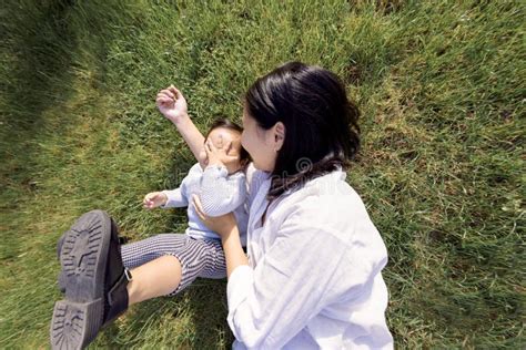 Asian Smiling Mom And Sweet Daughter Are Lying On A Green Lawn Stock Image Image Of Cute