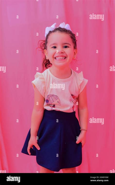 Cute Happy Small Argentinean Girl Standing On Pink Background Stock