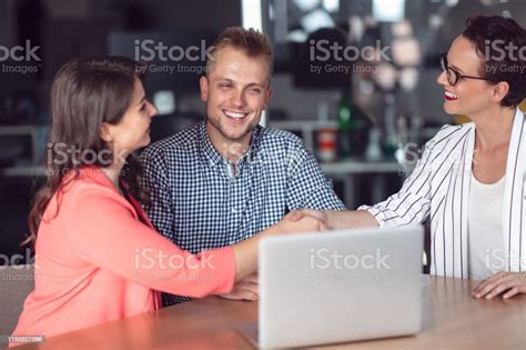 투자 고문 사무실에서 그녀의 책상에 앉아 친절 한 웃는 젊은 부부에 게 프리 젠 테이 션을 제공 3 명에 대한 스톡 사진 및