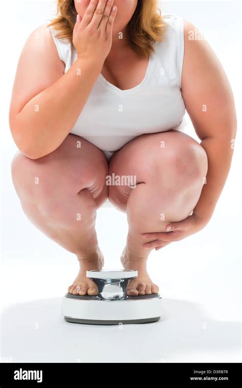 Diet And Weight Obese Young Woman Crouching On A Scale Measuring Her