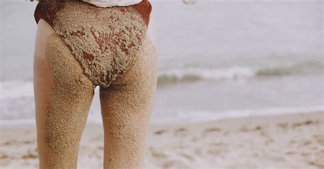 젊은 여자 엉덩이와 다리가 해변에서 닫힙니다 모래 수영복과 다리가 해변에서 휴식을 취하는 행복한 젖은 소녀 뒷모습 여름 방학 평온한 정통 순간 사진