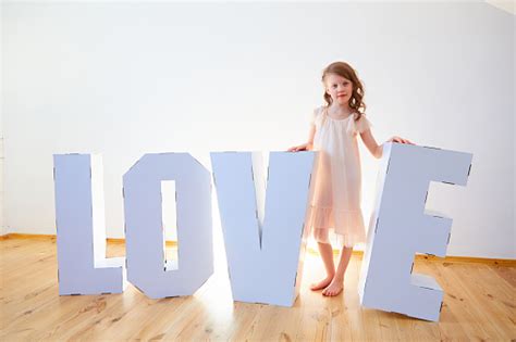 밝은 배경에 흰색 판지에서 단어 Love를 형성하는 큰 골판지 3d 서 편지와 함께 연주 소녀 7 세 관계 개념입니다 개념에
