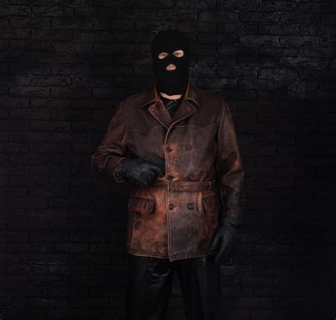 Bandido Enmascarado Con Un Arma De Fuego En Un Fondo Negro Foto Premium