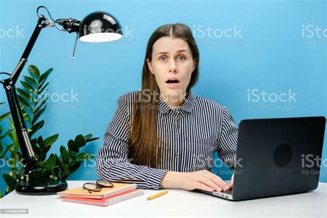 충격을 받은 젊은 직원 사업가 20대는 사무실에서 노트북 Pc 컴퓨터로 책상 작업에 앉아 카메라를 바라보며 스튜디오의 파란색
