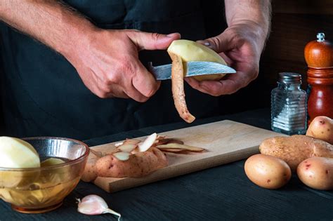 요리사는 으깬 감자 스튜 구운 야채와 함께 감자를 청소합니다 감자 요리 검은 배경 메뉴의 개념 요리 건강한 식생활 감자 요리에