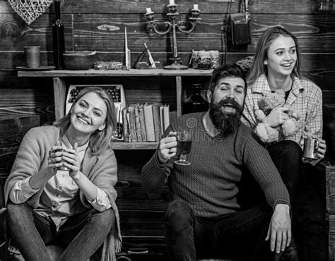 Friends Have Fun Speaking And Drinking Hot Drinks In Wooden Interior