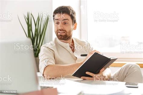 노트북과 노트북을 사용하여 흰색 셔츠를 입은 성공적인 사무직 30 대의 이미지 현대적인 직장에서 테이블에 앉아있는 동안 30