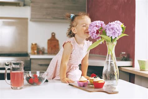 Portrait Of A Little Cute Girl Sniffing A Bunch Of Hydrangeas The Girl