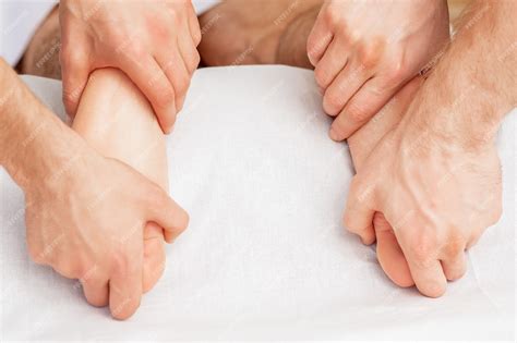 Premium Photo Hands Of Two Massagers Are Giving Massage To Soft Bare