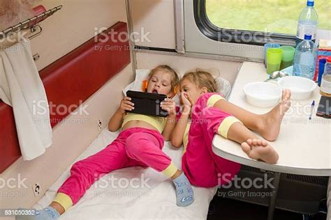 Dua Gadis Kecil Berbaring Di Kereta Dengan Kakinya Foto Stok Unduh