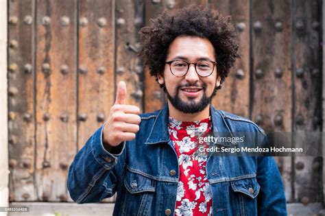 Latino Nonbinary Person With Glasses And Afro Hairstyle Giving A Thumbs