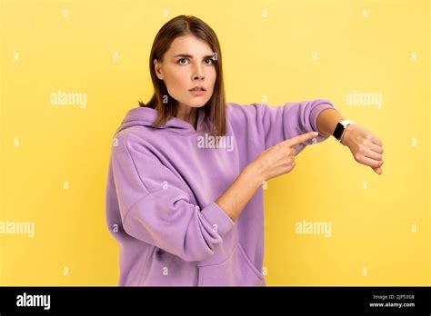 Portrait Of Bossy Woman With Dark Hair Pointing Wrist Watch And Looking