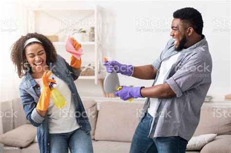 함께 평면 청소하는 동안 분무기와 함께 연주 쾌활한 아프리카 계 미국인 커플 2명에 대한 스톡 사진 및 기타 이미지 2명