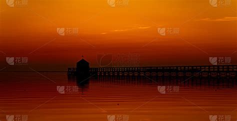 日落后的海滩上的大木制码头