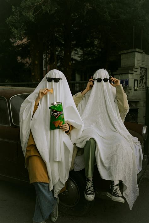 People Dressed As Ghosts Wearing Sunglasses And Eating Crisps · Free