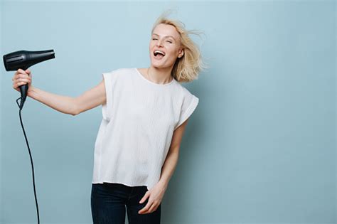 재미 금발의 여자 불고 자신 에 A 얼굴 와 A 헤어 드라이어 위에 블루 헤어드라이어에 대한 스톡 사진 및 기타 이미지 헤어드라이어 바람 아름다움 Istock