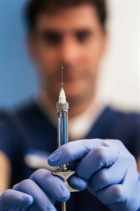 Doctor With Syringe Is Preparing For Injection By Stocksy Contributor