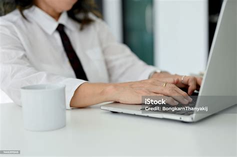 그녀의 책상에서 노트북을 사용하고 키보드로 타이핑하는 전문 아시아 노인 사업가 50 59세에 대한 스톡 사진 및 기타 이미지