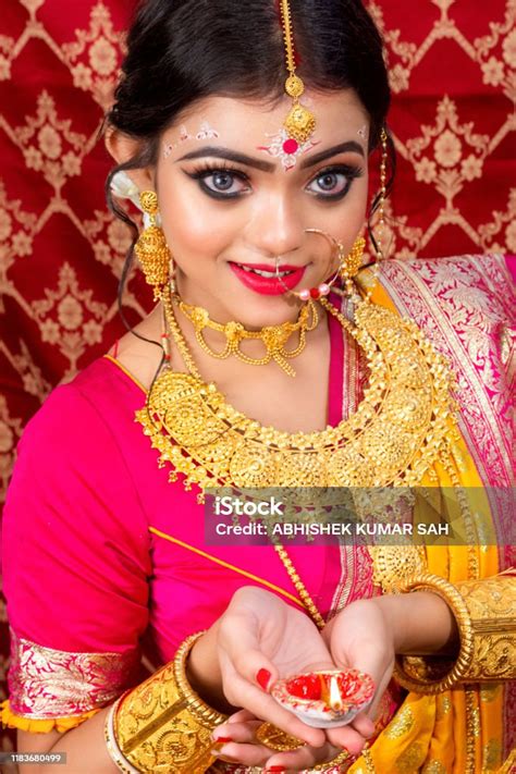디왈리를 계기로 꽃을 배경으로 오일 램프 조명이나 디야를 들고 전통 사리 드레스를 입은 아름다운 젊은 인도 여성 Onam에 대한 스톡 사진 및 기타 이미지 Istock